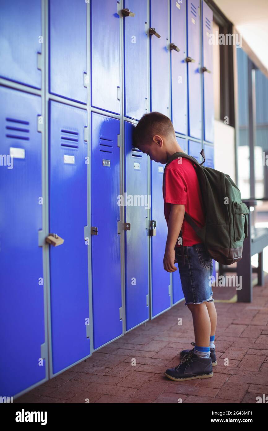 Side view of boy leaning on lockers in corridor Stock Photo - Alamy