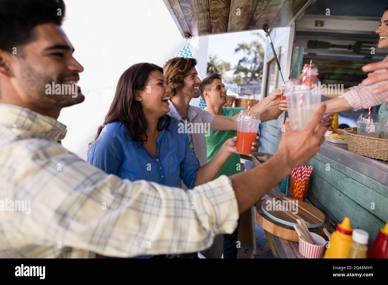 Waitress and waiter giving juice to customer at counter Stock Photo - Alamy