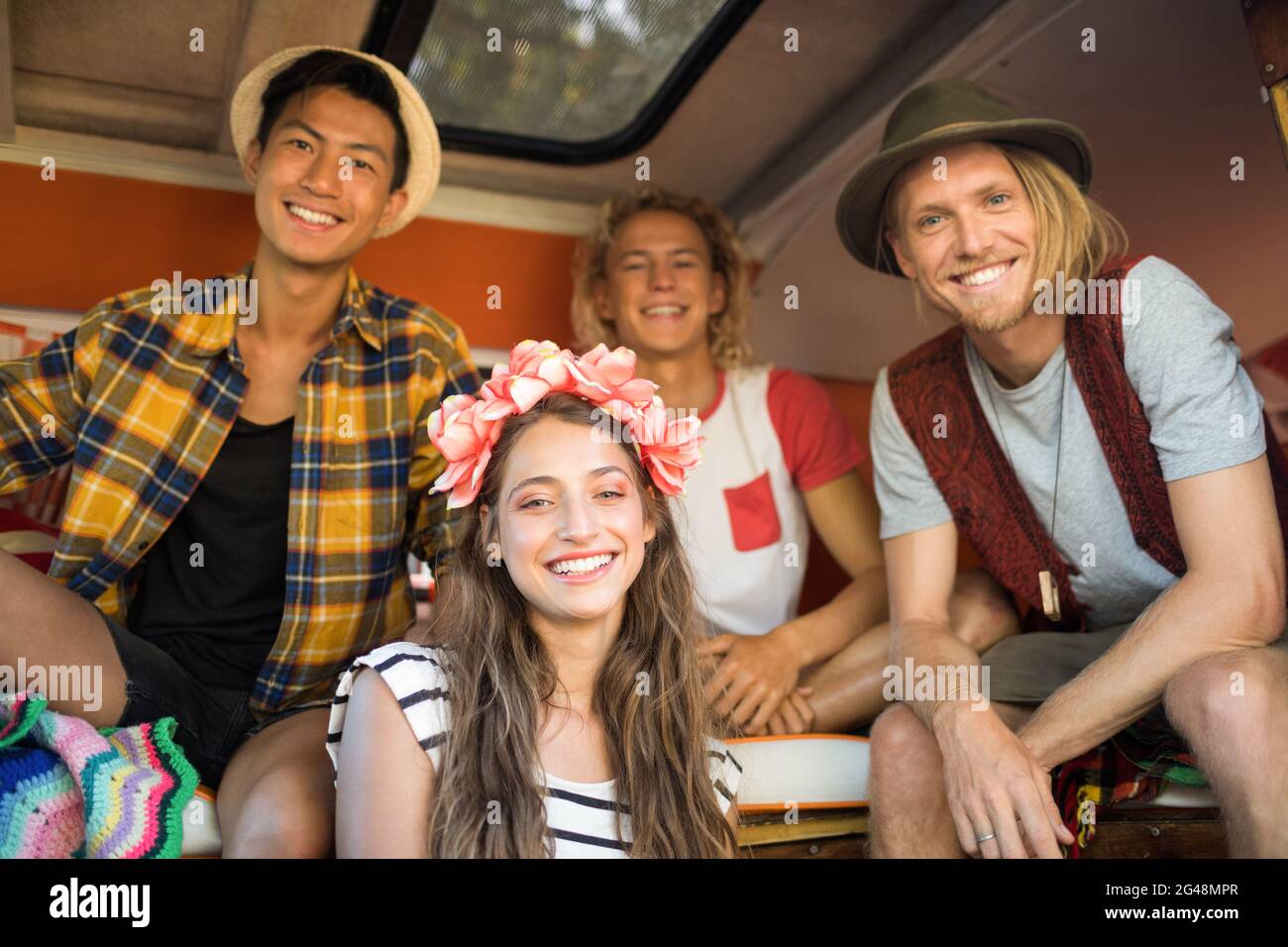 Smiling young friends sitting together in camper van Stock Photo - Alamy