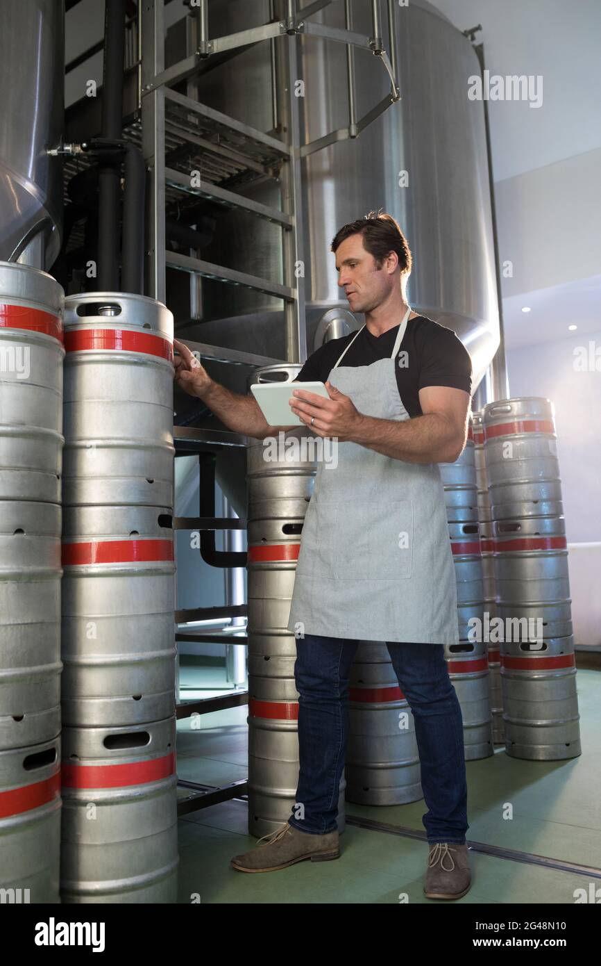Full length of worker counting kegs at warehouse Stock Photo - Alamy
