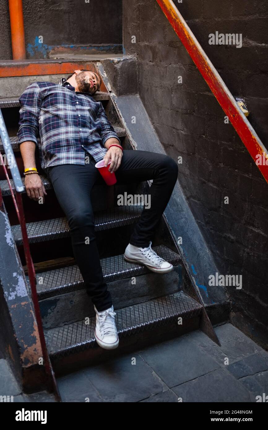 Drunk man lying on staircase Stock Photo - Alamy