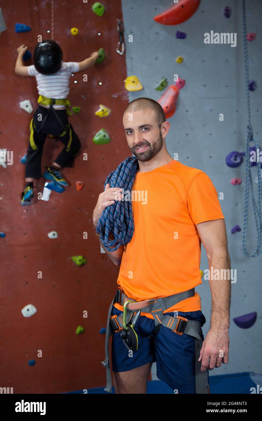 Trainer standing with rope in fitness studio Stock Photo - Alamy