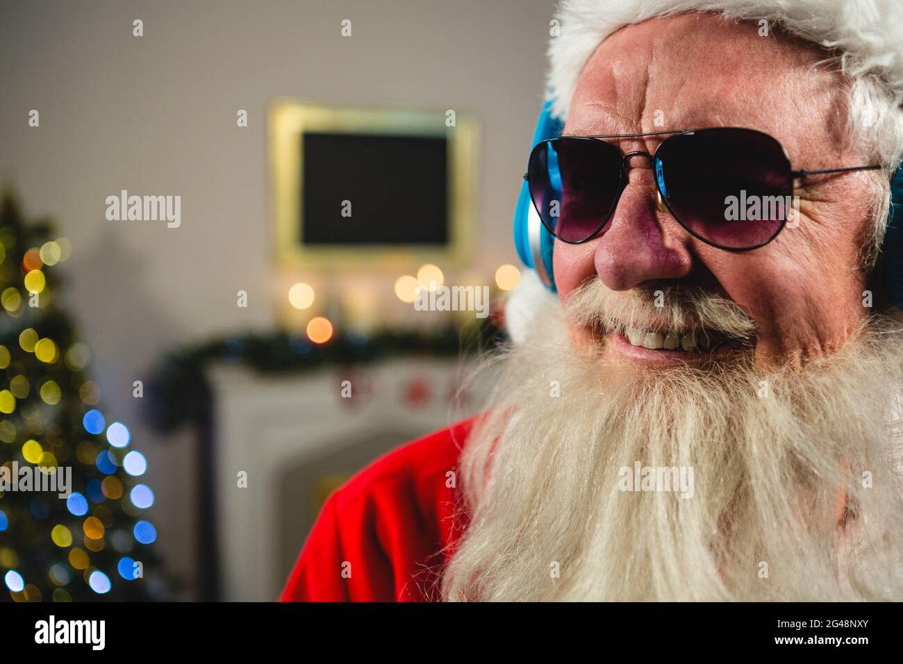 Santa Claus listening to music on headphones Stock Photo - Alamy