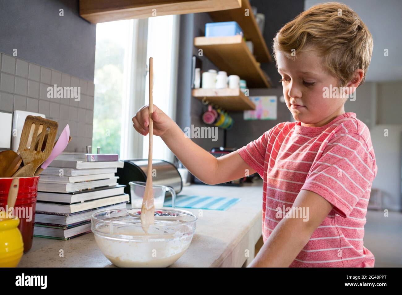 Boy mixing batter at counter Stock Photo - Alamy