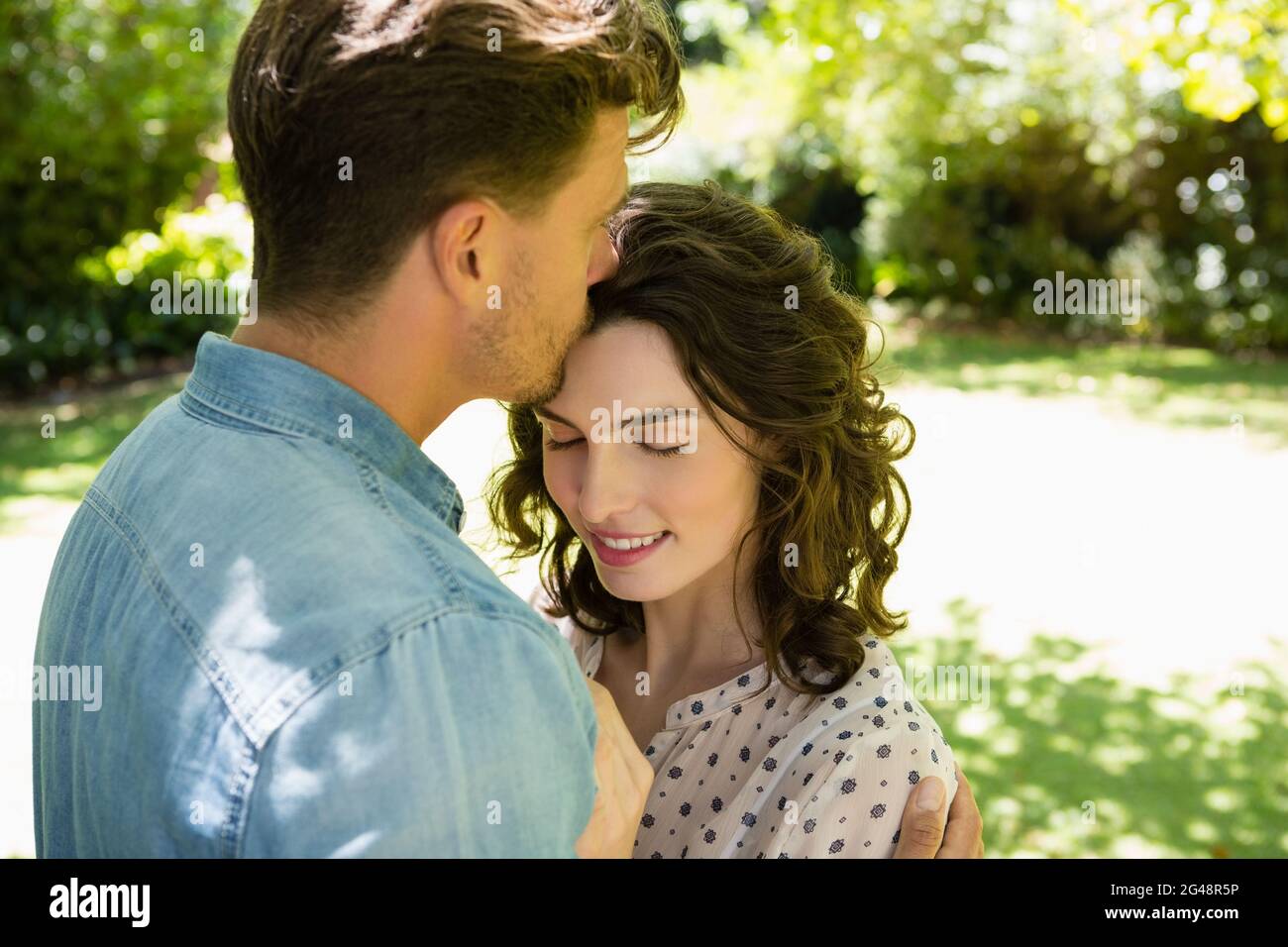 Man kissing woman on forehead Stock Photo - Alamy