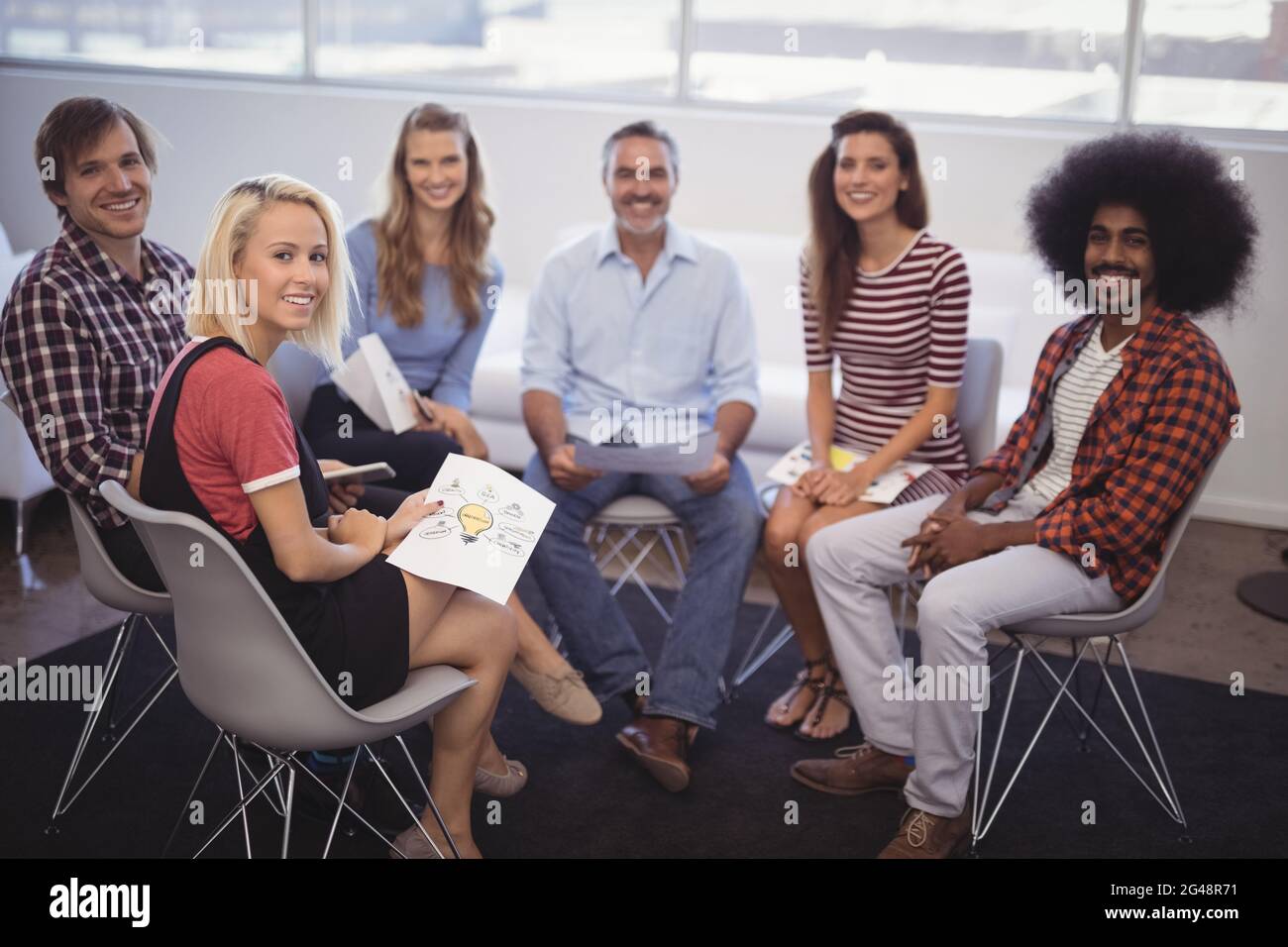 Business people sitting on chairs during meeting in creative office ...