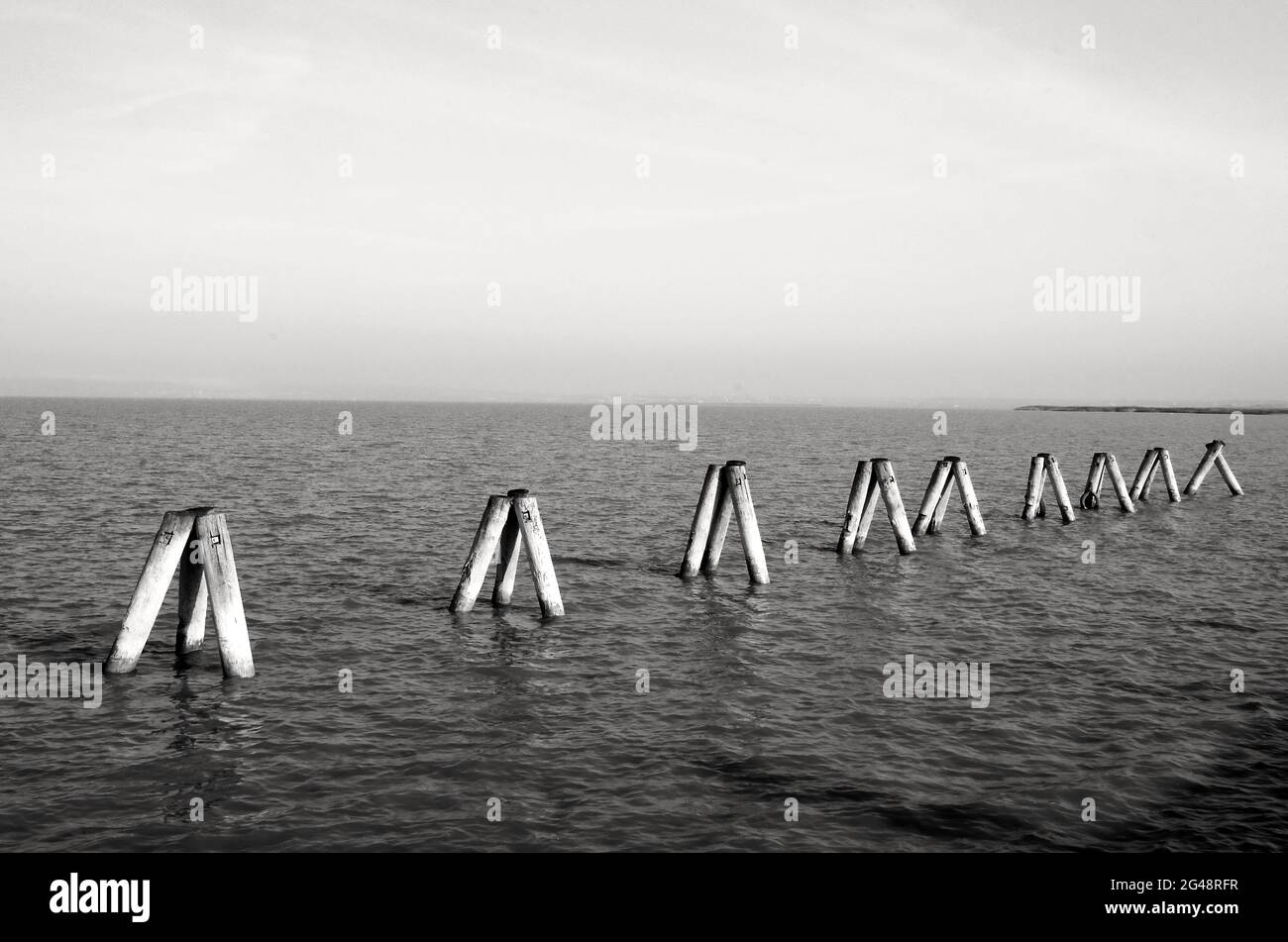 Wooden wave breakers in the sea. Black and white panorama at sea ...