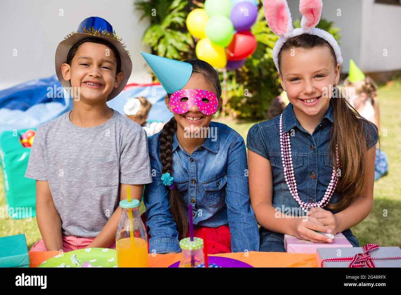 Portrait three children sitting table hi-res stock photography and ...