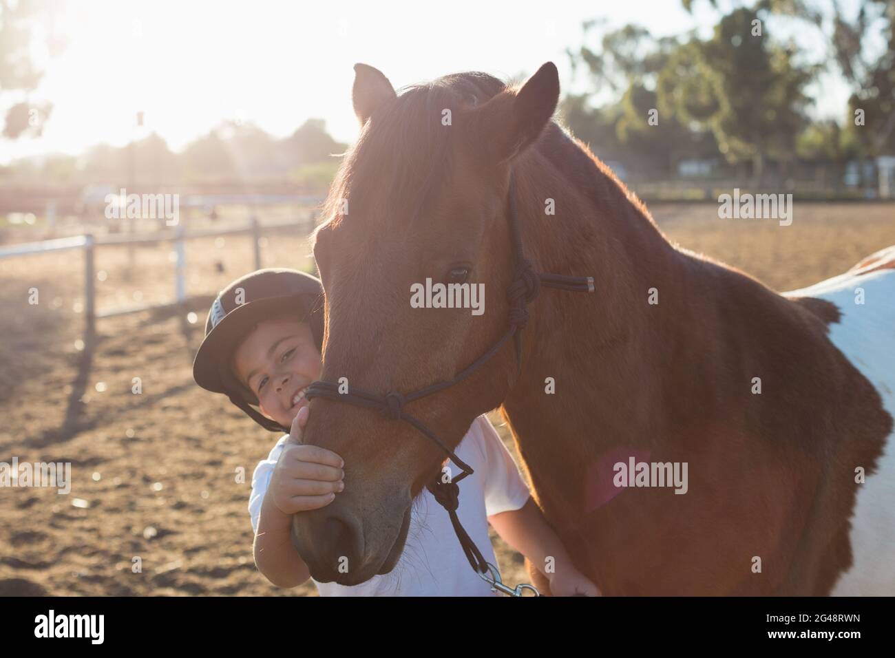 Rider boy caressing a horse in the ranch Stock Photo - Alamy