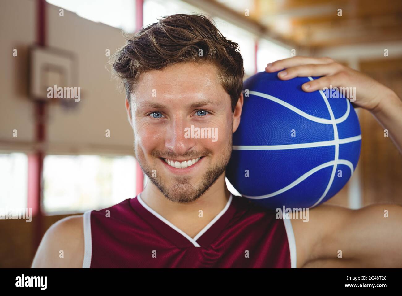Close up portrait of smiling basketball player holding ball Stock Photo ...