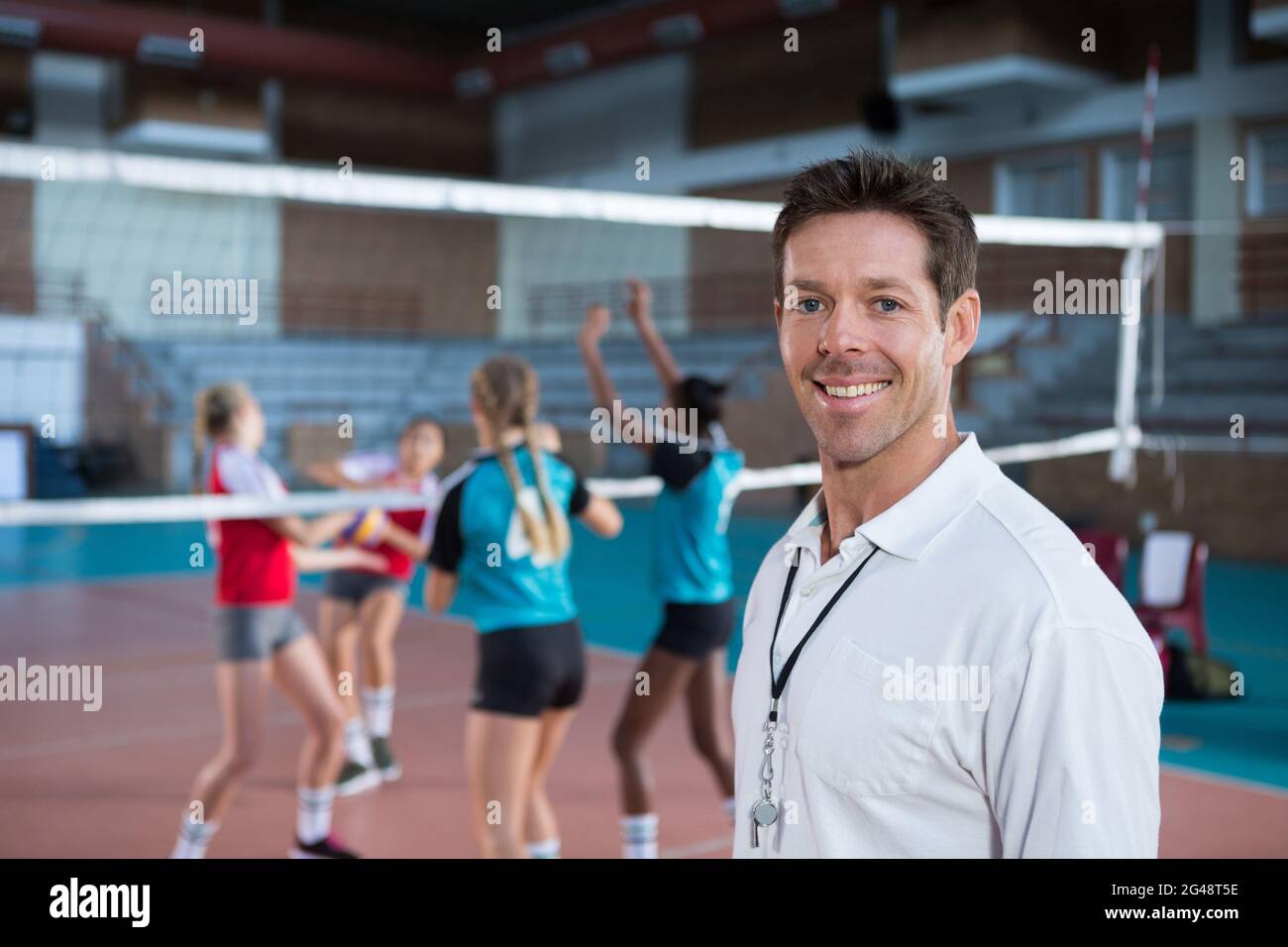 Smiling coach standing in the volleyball court Stock Photo - Alamy