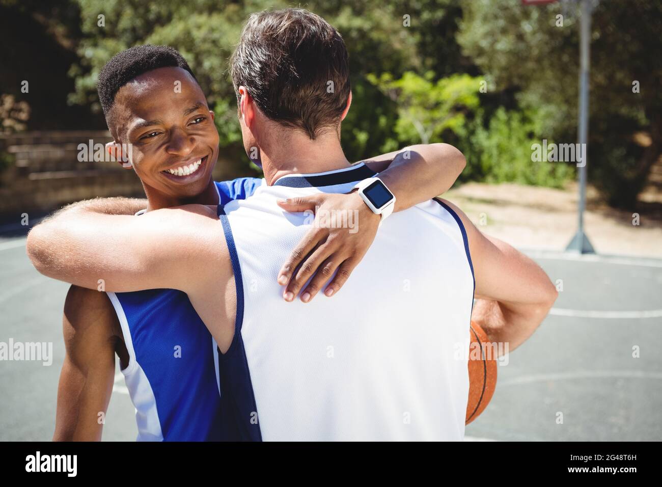 Happy basketball players embracing Stock Photo - Alamy