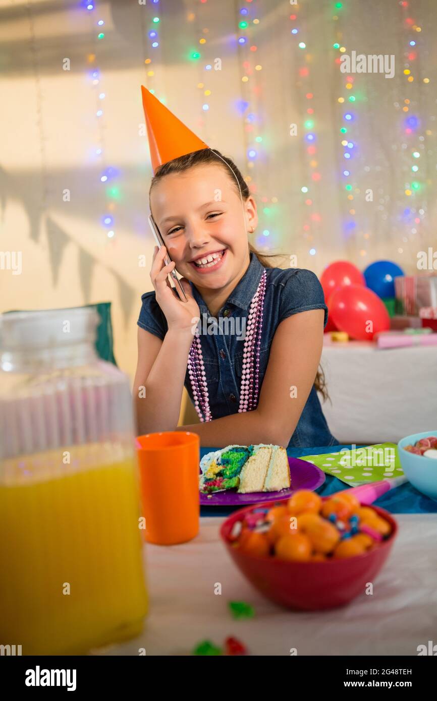 Girl talking on mobile phone during birthday party Stock Photo - Alamy