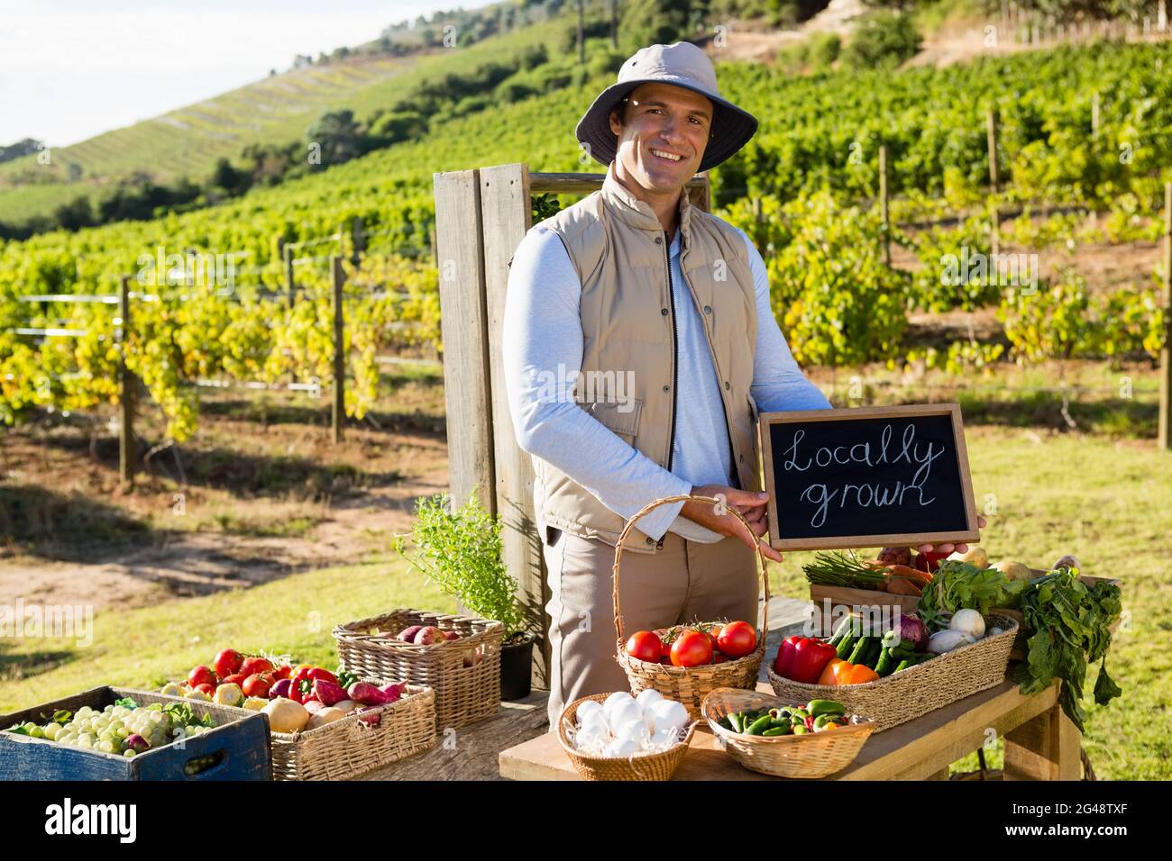 Portrait of happy man standing with slate at vegetable stall Stock ...