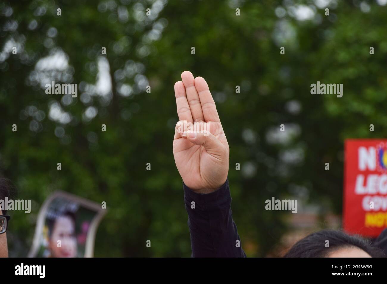 A protester holds up the three-finger salute in Parliament Square ...