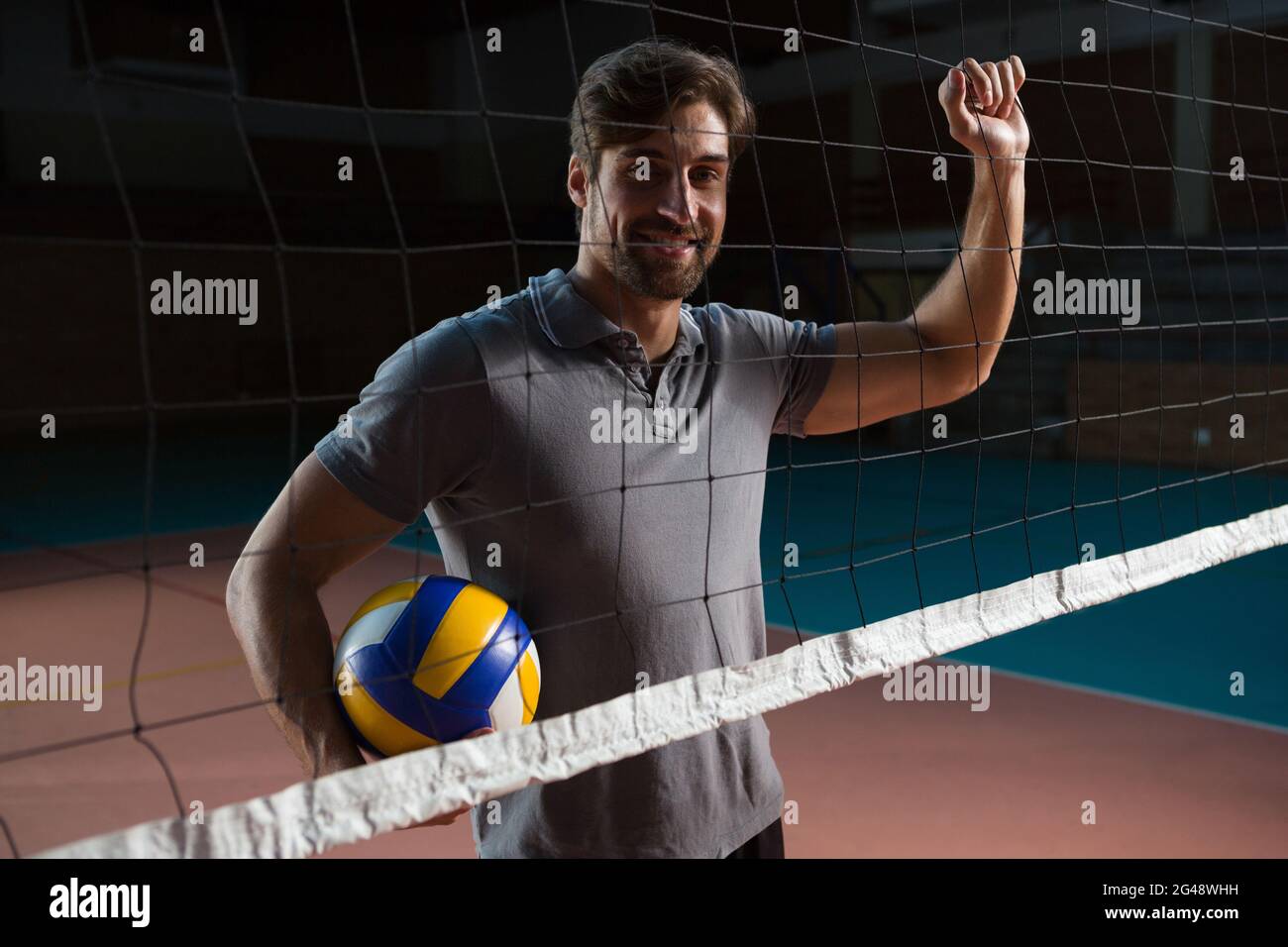 Portrait of male player holding volleyball Stock Photo - Alamy