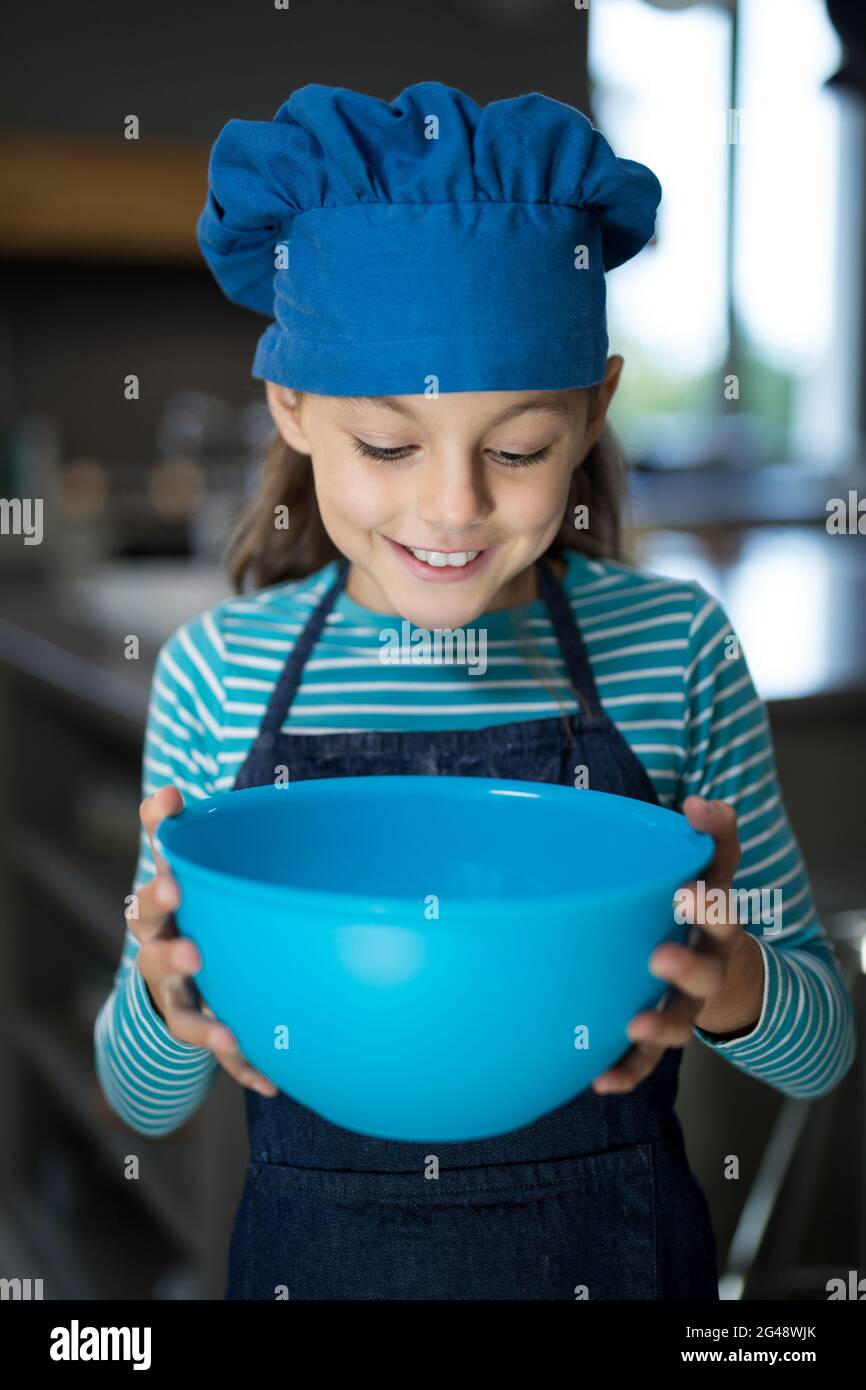 Smiling girl looking into the bowl in the kitchen Stock Photo - Alamy