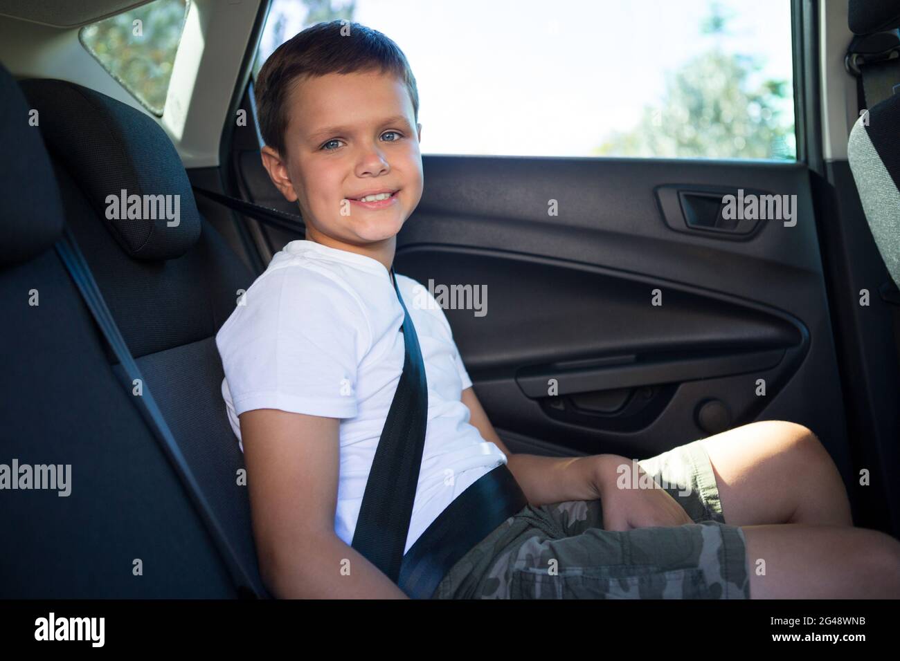 Happy teenage boy sitting in the back seat of car Stock Photo - Alamy