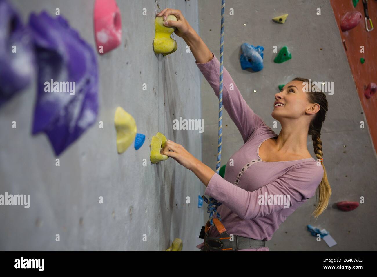 Smiling woman climbing in rock wall hi-res stock photography and images ...