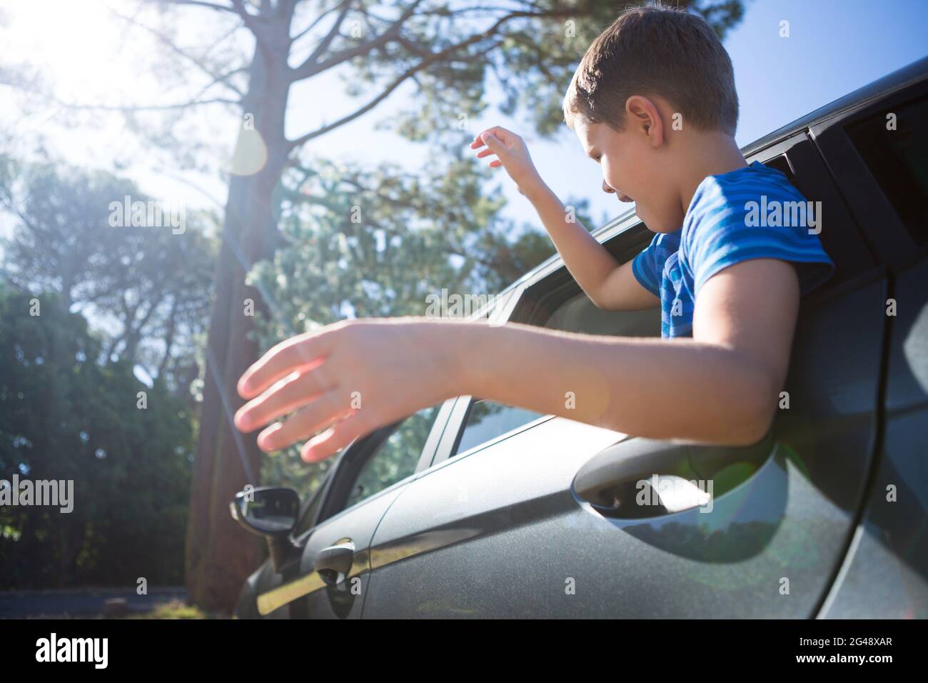Teenage boy looking from open car window Stock Photo - Alamy