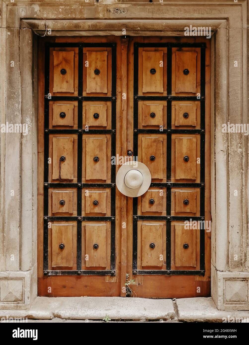 Sun hat hanging on handle of old brown door made of solid wood Stock ...