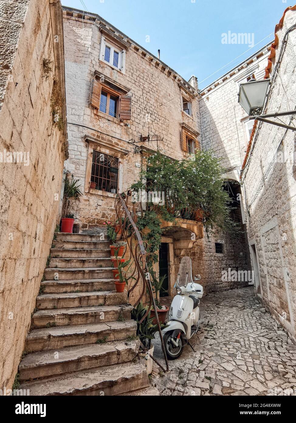 Small square in old town with stone houses and idyllic staircase ...