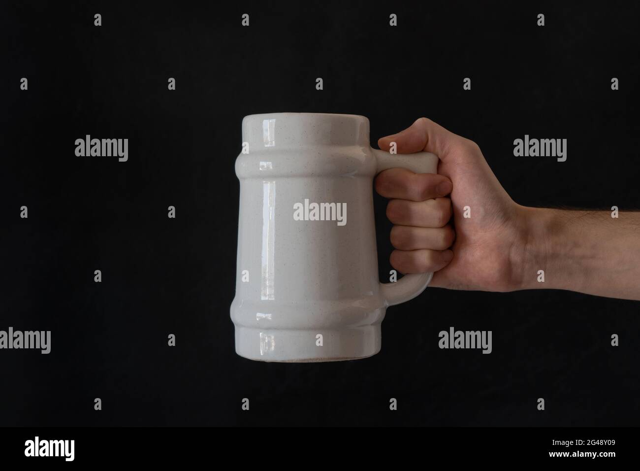 Man's hand holding a white ceramic beer mug Stock Photo - Alamy