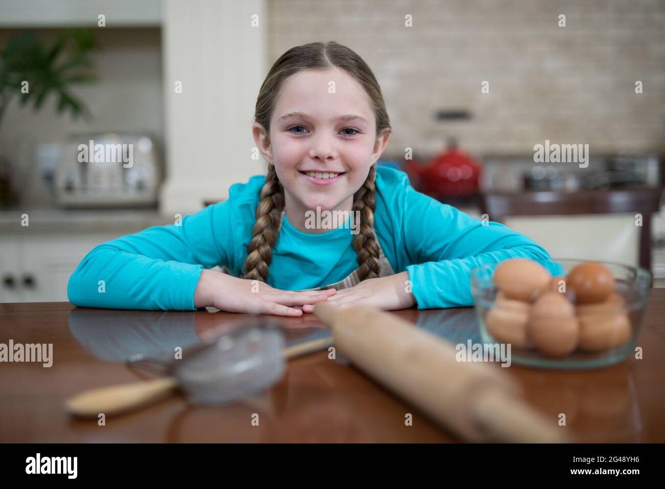 Girl sitting on kitchen table hi-res stock photography and images - Alamy