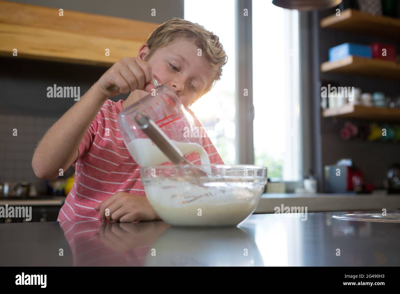 Boy pouring milk in batter at kitchen Stock Photo - Alamy