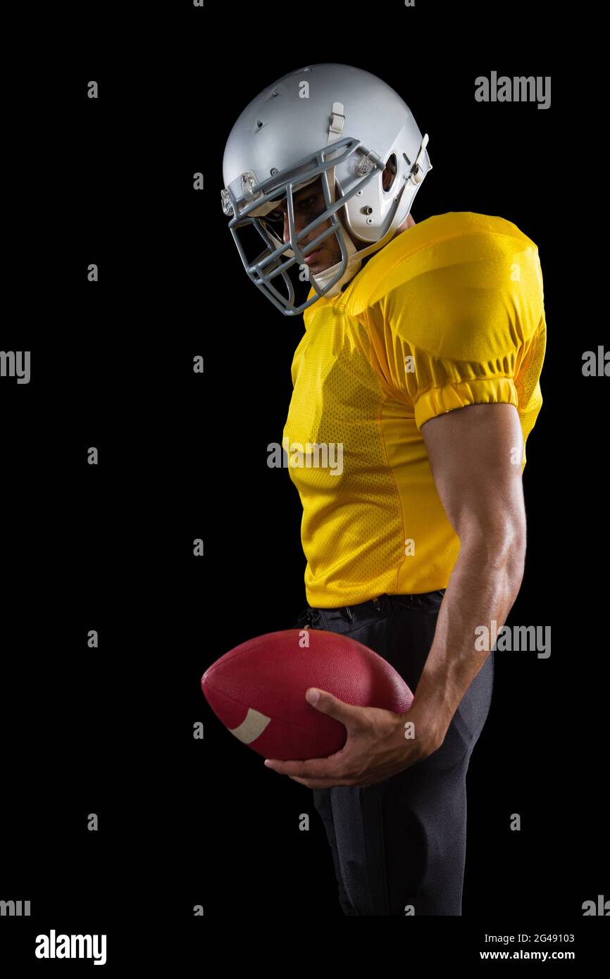 American football player holding a ball Stock Photo - Alamy