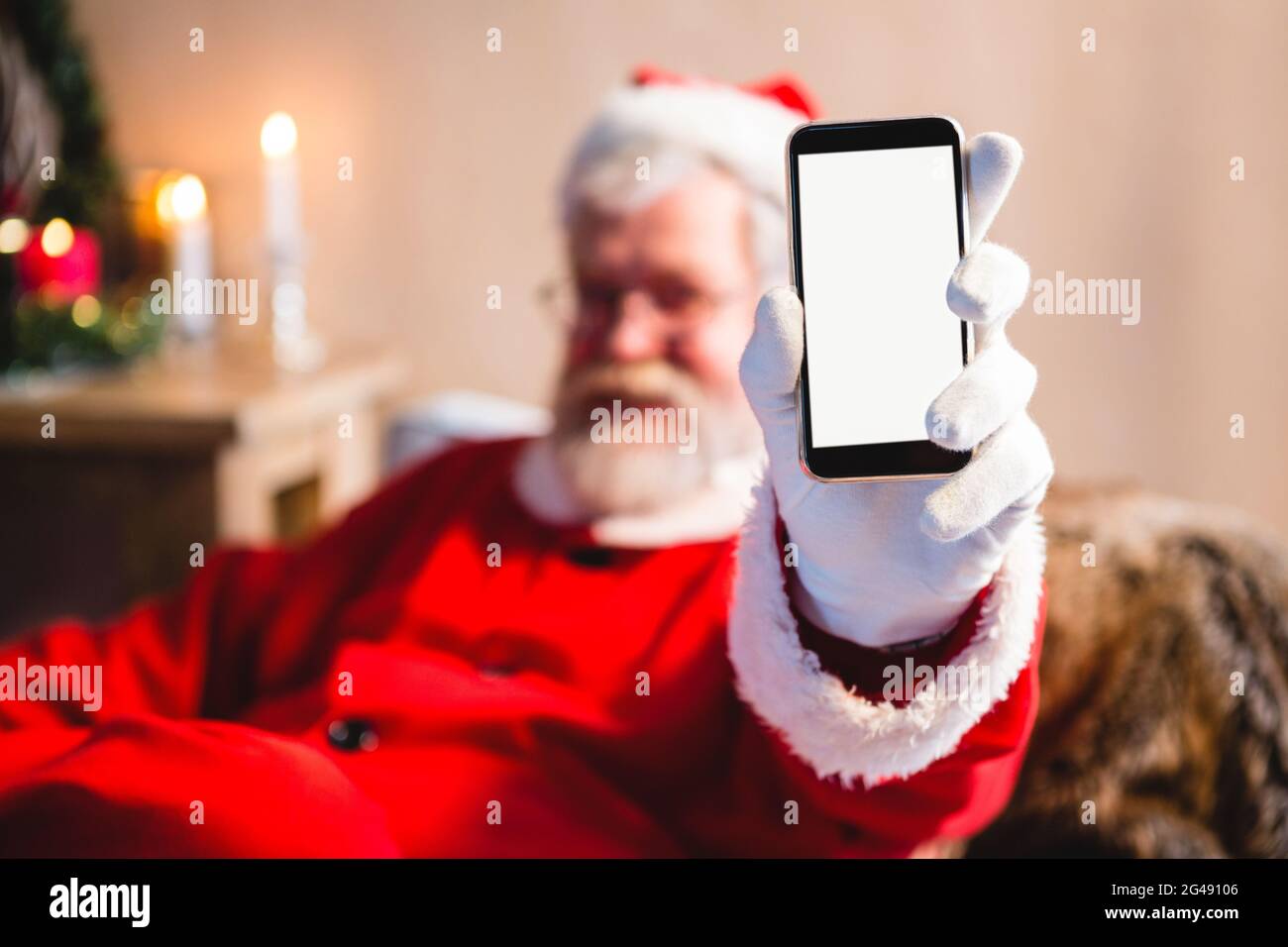 Santa claus sitting and showing his smartphone Stock Photo - Alamy