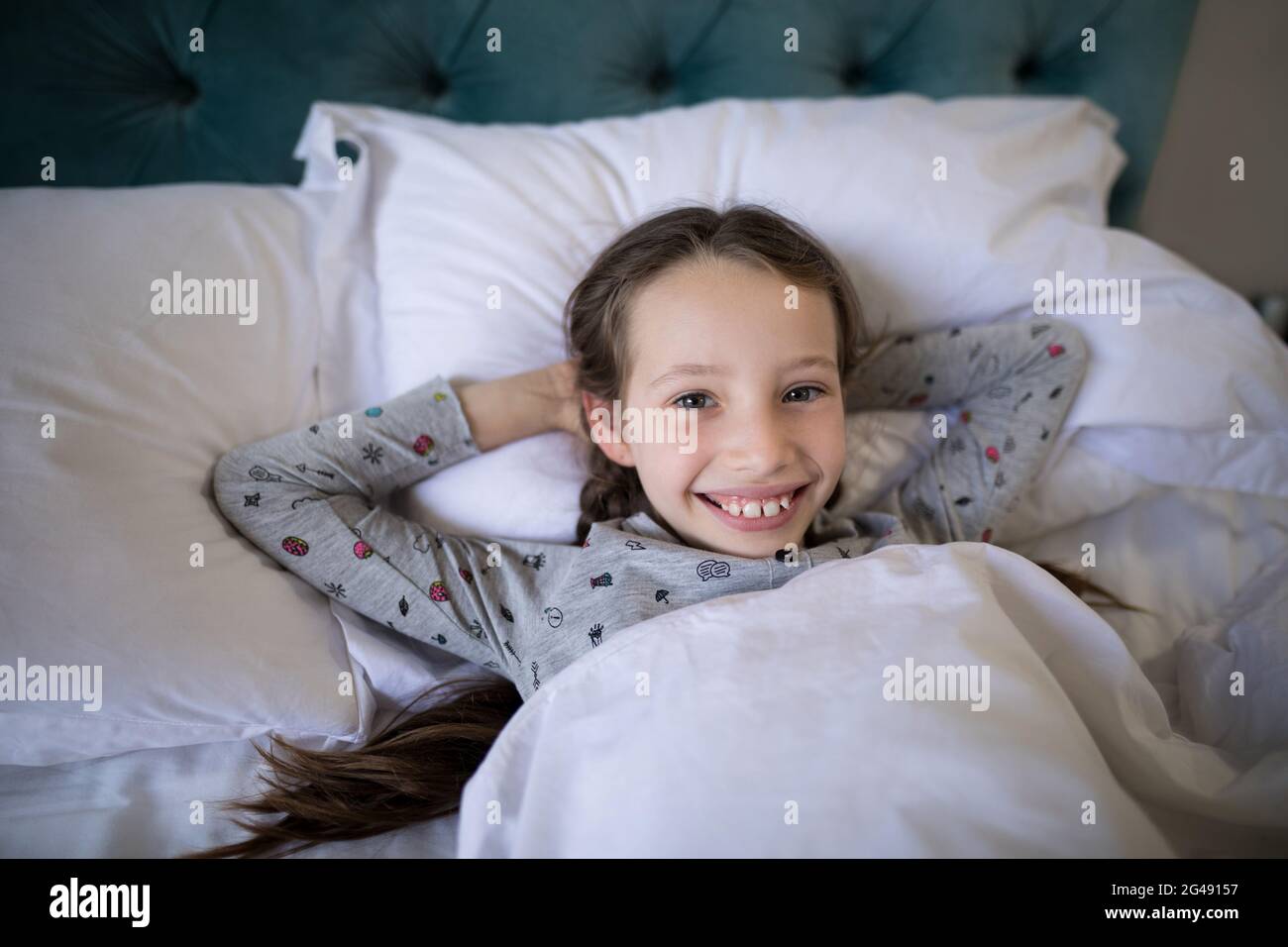 Smiling girl lying on bed in bedroom Stock Photo - Alamy