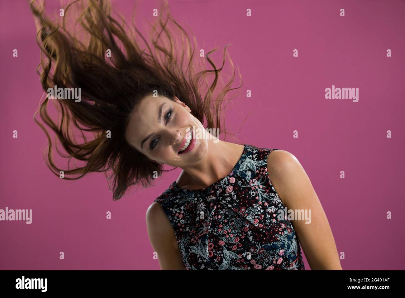 Smiling woman tossing her long hair Stock Photo - Alamy