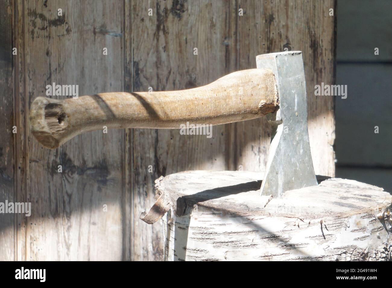 Closeup shot of an ax stuck in a tree stump on the wooden wall ...