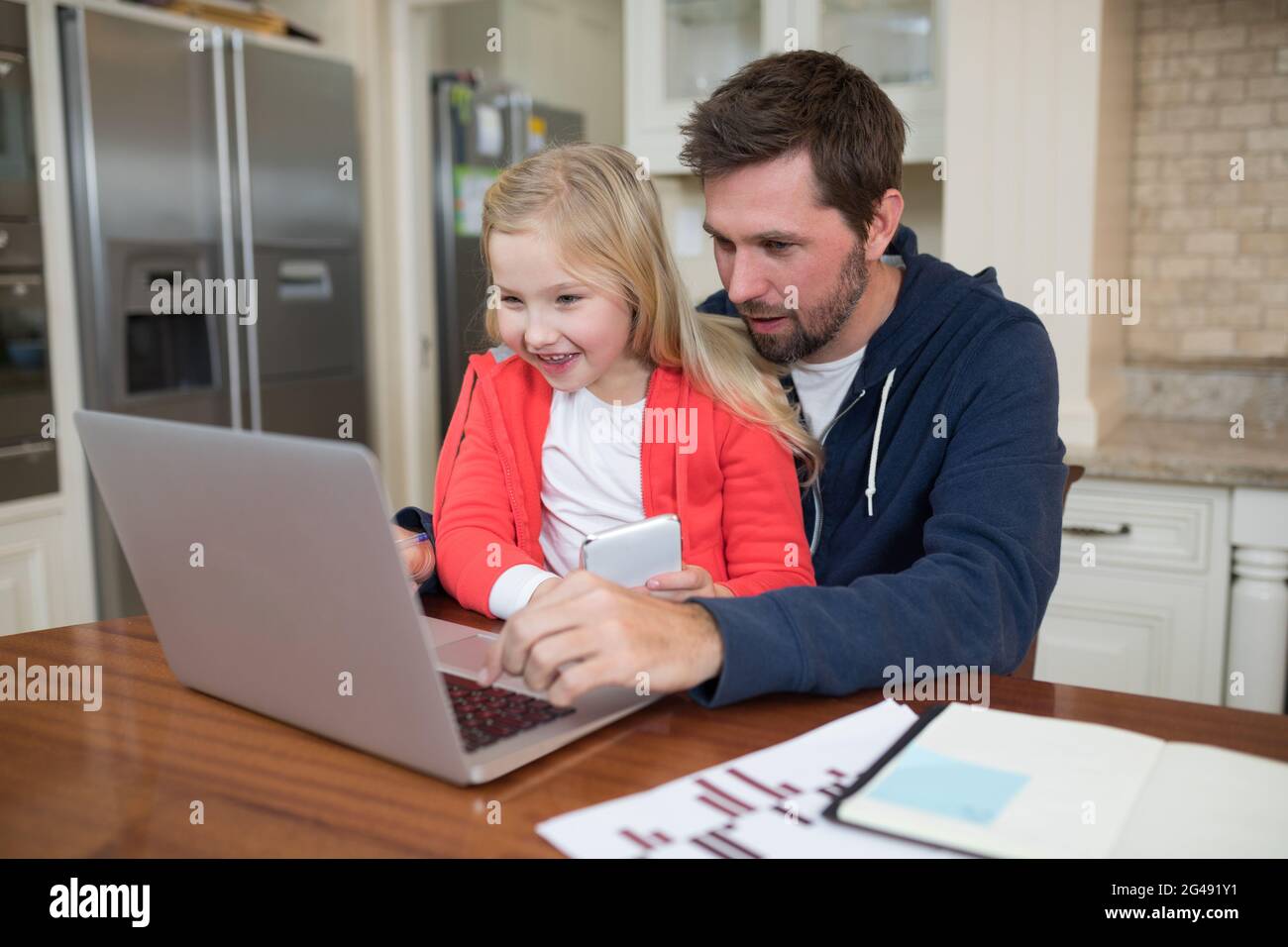 Father and daughter working on laptop Stock Photo - Alamy