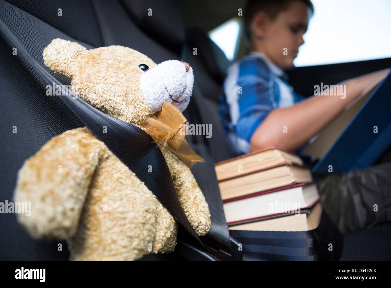 Teenage boy reading book in the car Stock Photo - Alamy
