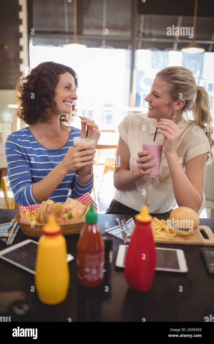 Female friends speaking cafe hi-res stock photography and images - Alamy
