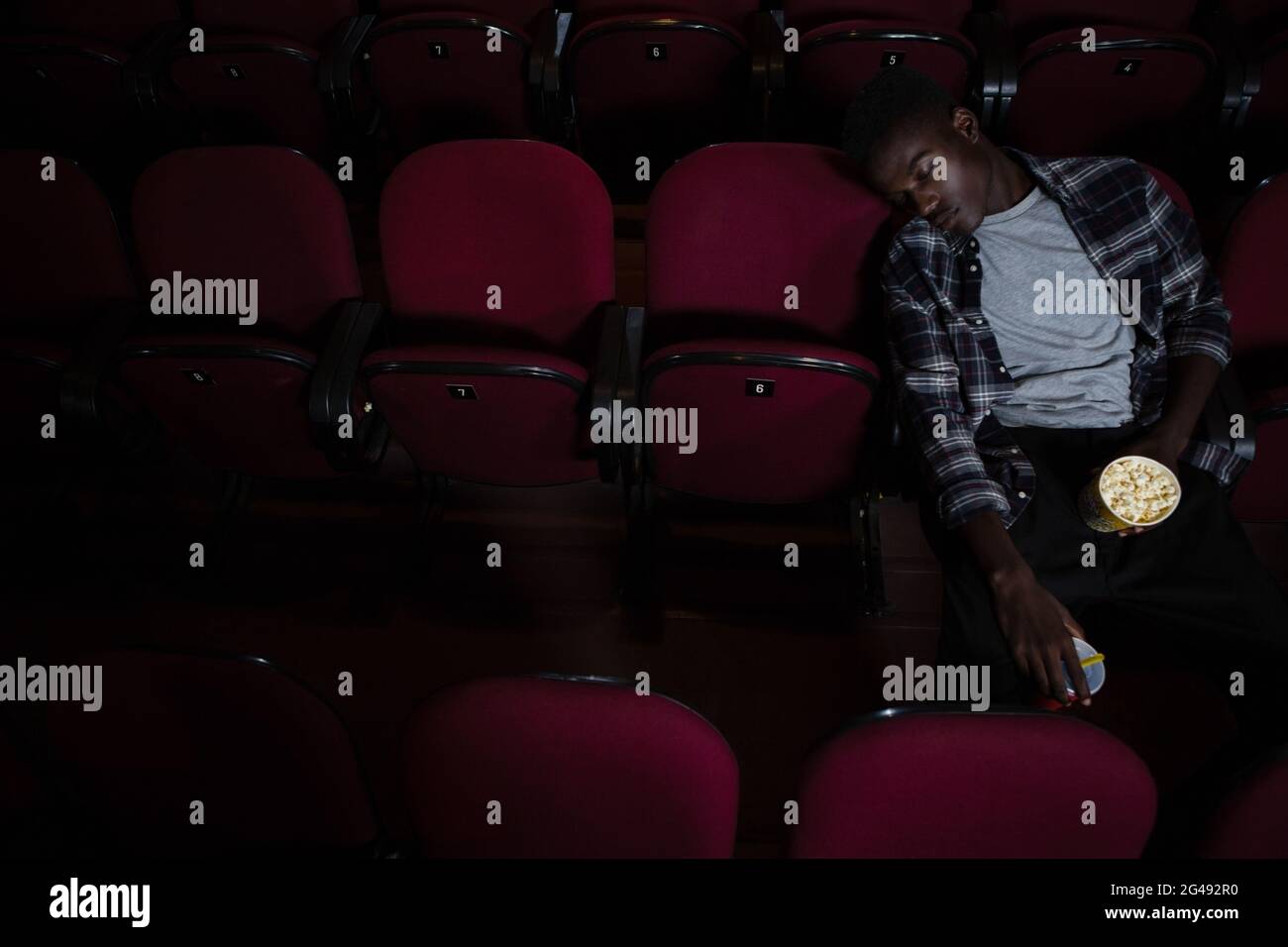 Man with popcorn sleeping in theatre Stock Photo - Alamy