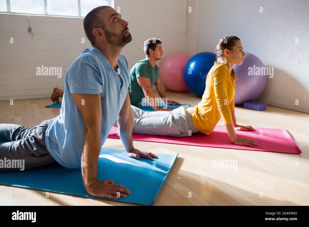 Instructor training students in practicing cobra pose at health club ...