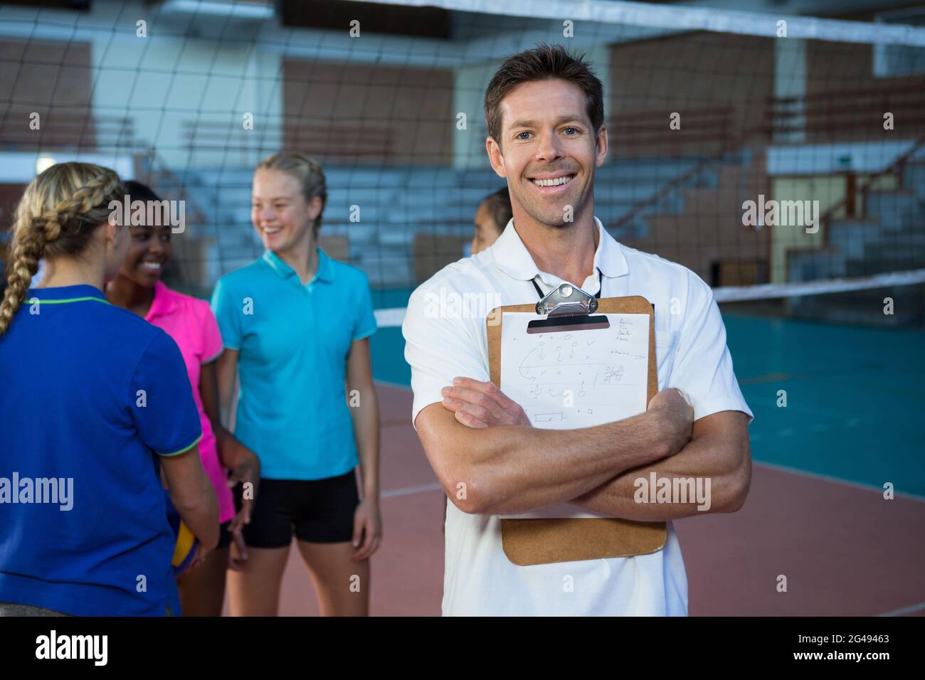 Smiling male coach standing in the volleyball court Stock Photo - Alamy