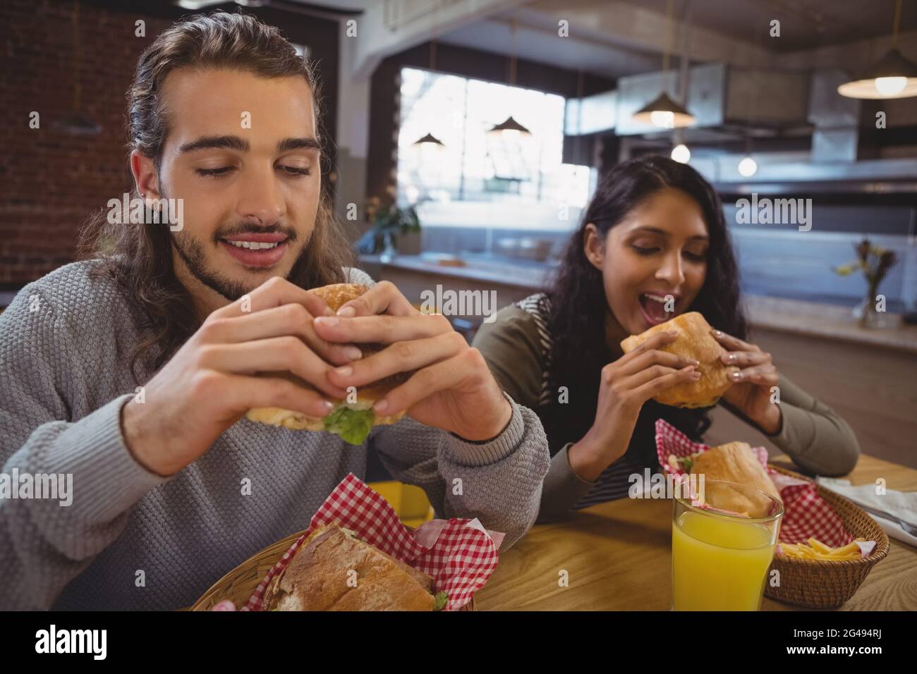 Friends eating burgers in cafe Stock Photo - Alamy