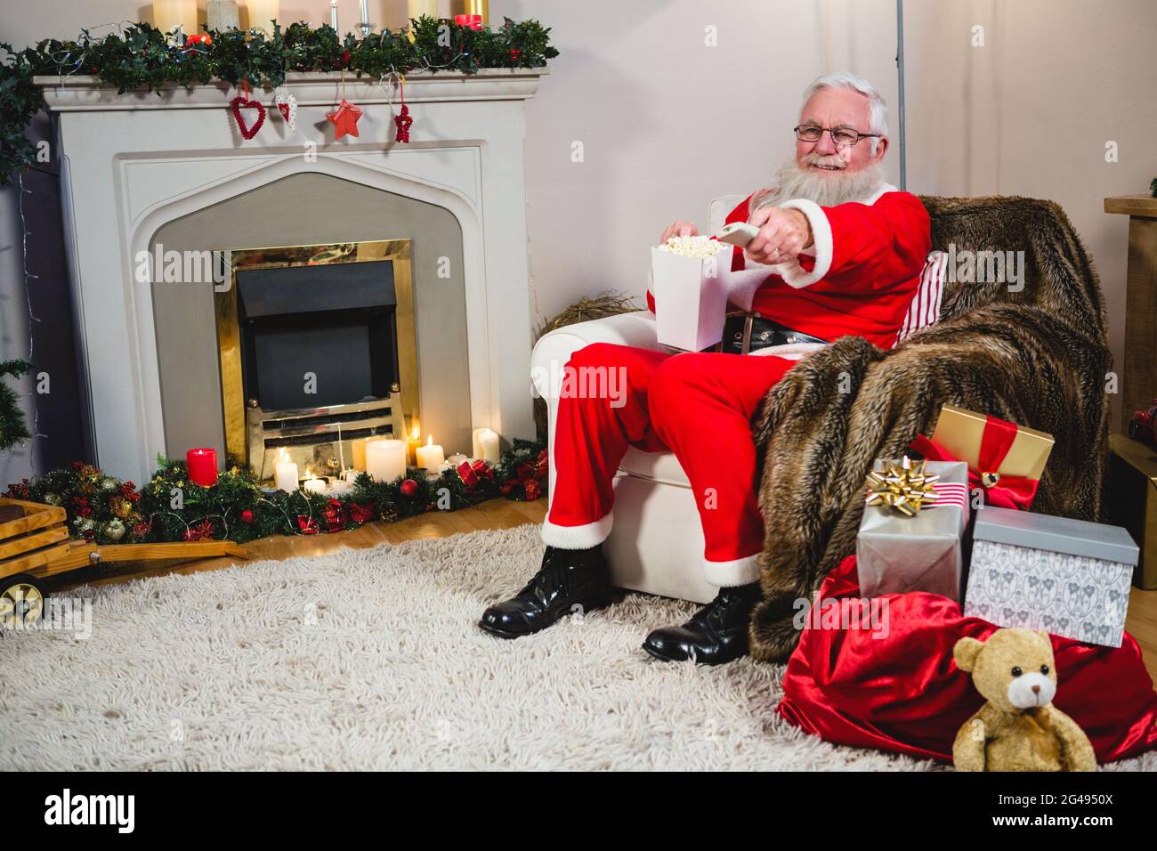Santa Claus holding television remote control Stock Photo - Alamy