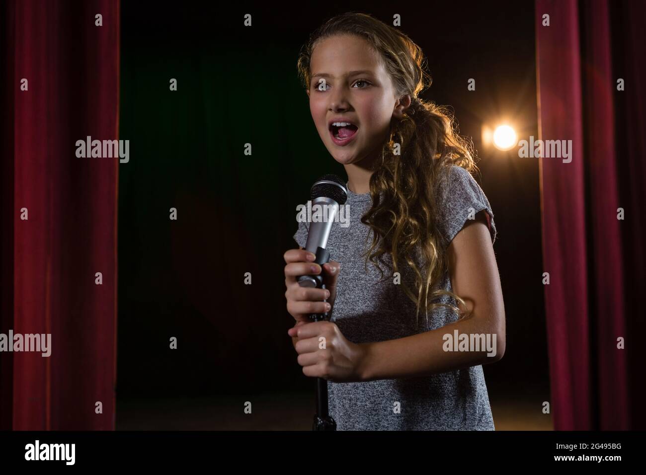 Female artist singing song on stage Stock Photo - Alamy