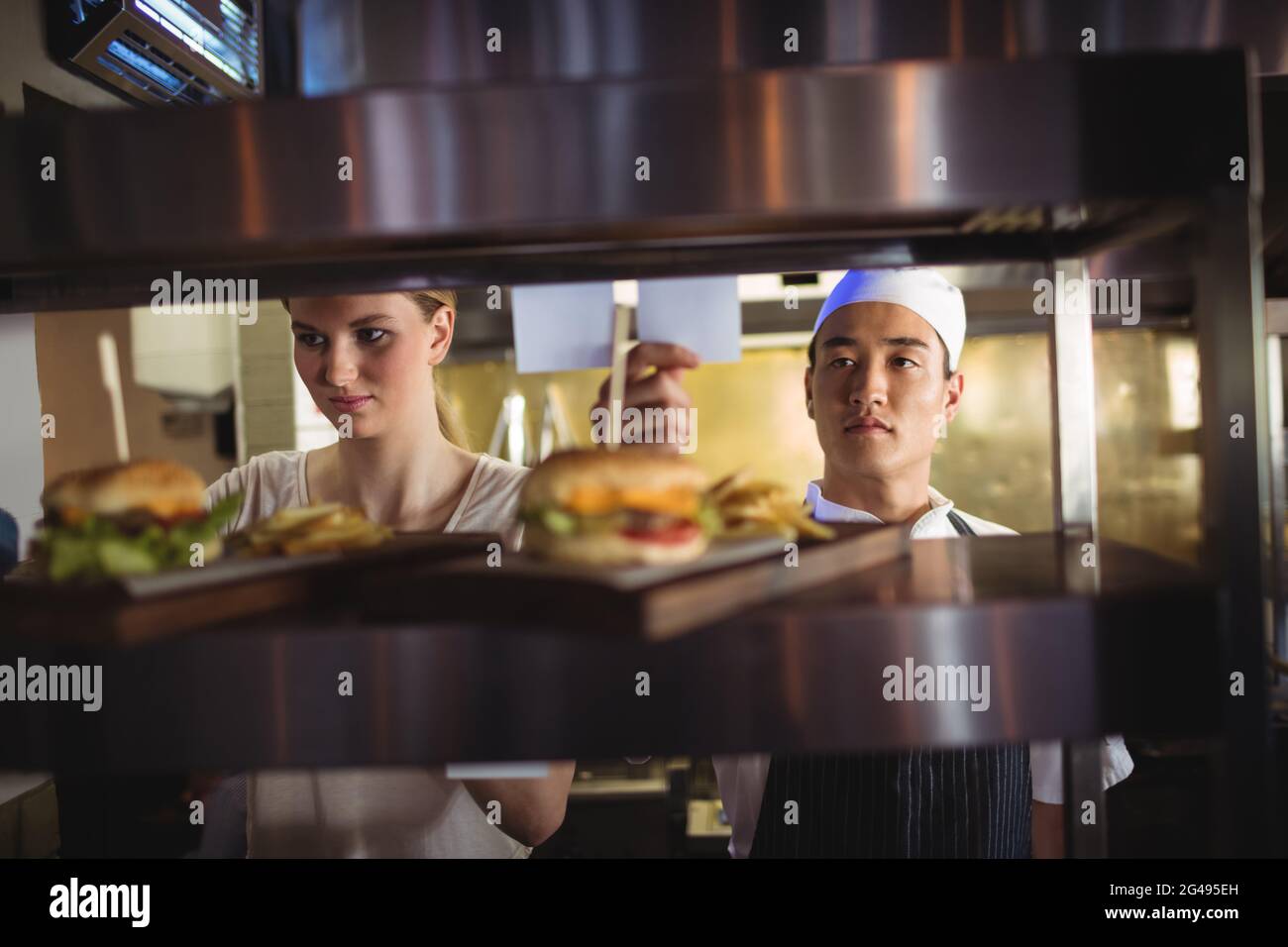 Chef looking at an order list in the commercial kitchen Stock Photo - Alamy