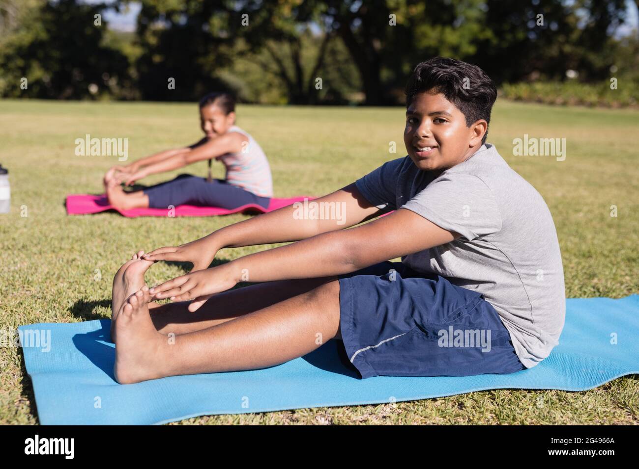 Portrait of boy touching toes during yoga glass Stock Photo - Alamy