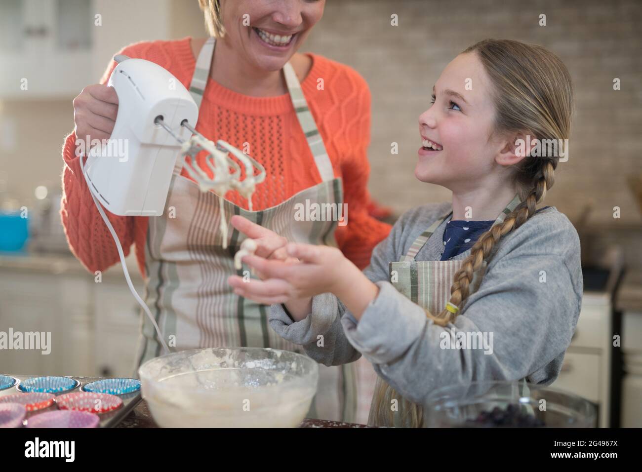Mother and daughter mixing eggs and wheat flour in a bowl Stock Photo ...