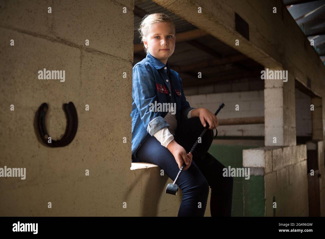 Girl sitting in stable Stock Photo - Alamy
