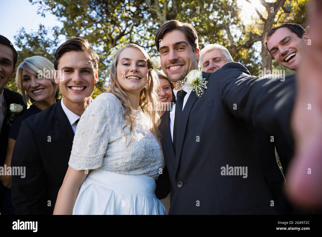 Happy couple posing with guests during wedding Stock Photo - Alamy