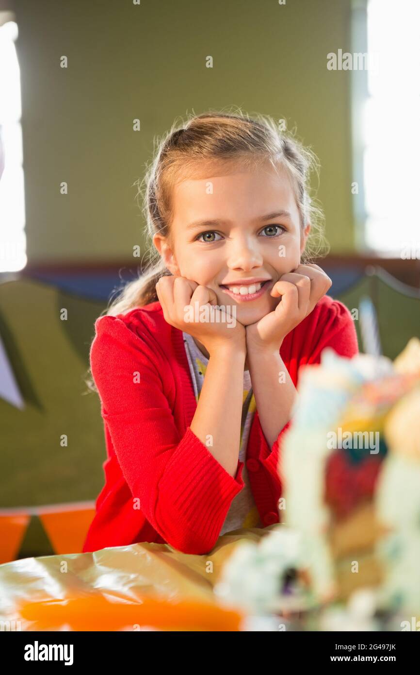 Portrait of cute girl sitting at table during birthday party Stock ...