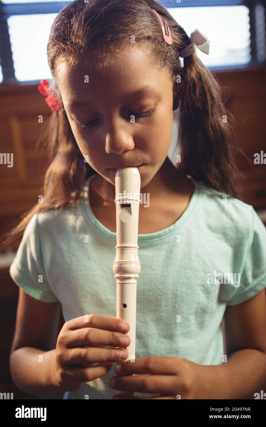 Girl playing flute in classroom Stock Photo - Alamy